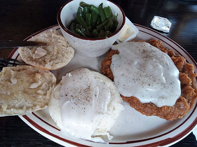 Behold the chicken fried steak in all its glory – a golden-crusted masterpiece swimming in peppery gravy alongside real mashed potatoes. Comfort food nirvana.