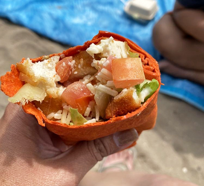 Beach dining reinvented: a vibrant wrap bursting with fresh ingredients, proving that portable food doesn't have to sacrifice flavor for convenience.