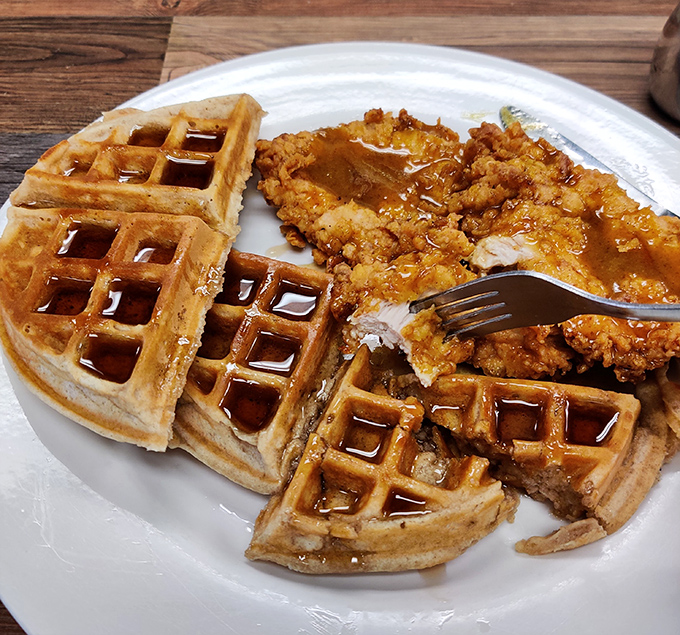 The legendary chicken and waffle arrives like a religious experience&mdash;crispy pecan-fried chicken embracing golden waffles in a maple syrup baptism.