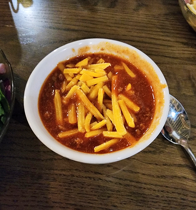 The legendary chili arrives like a celebrity, crowned with a shower of shredded cheddar. This bowl doesn't just satisfy hunger&mdash;it creates lifelong cravings.