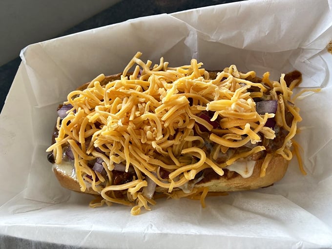 This mountain of melted cheese atop a perfectly grilled dog isn't just food&mdash;it's an engineering marvel that somehow stays intact until the first glorious bite.