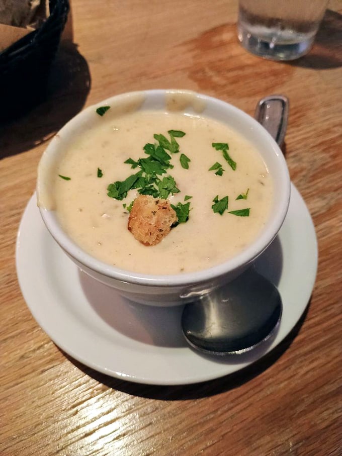 The holy grail of comfort food: New England Clam Chowder garnished with fresh herbs and a golden crouton. One spoonful and you'll understand why people make pilgrimages for this creamy masterpiece.