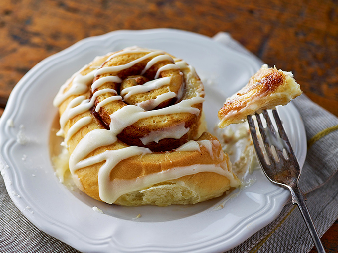 Behold the cinnamon roll in its natural habitat—a perfect spiral of dough, cinnamon, and icing that makes Monday mornings bearable again.