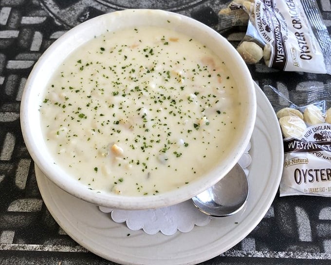 This isn't just clam chowder; it's a creamy ocean symphony sprinkled with fresh herbs and served with classic oyster crackers.