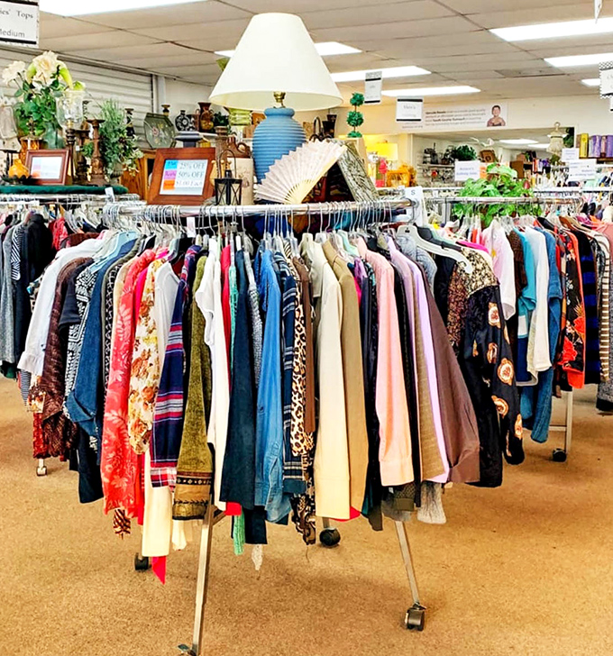 A circular rack bursting with colorful garments stands like a textile color wheel. Each hanger holds not just clothing, but potential new identities waiting to be tried on.
