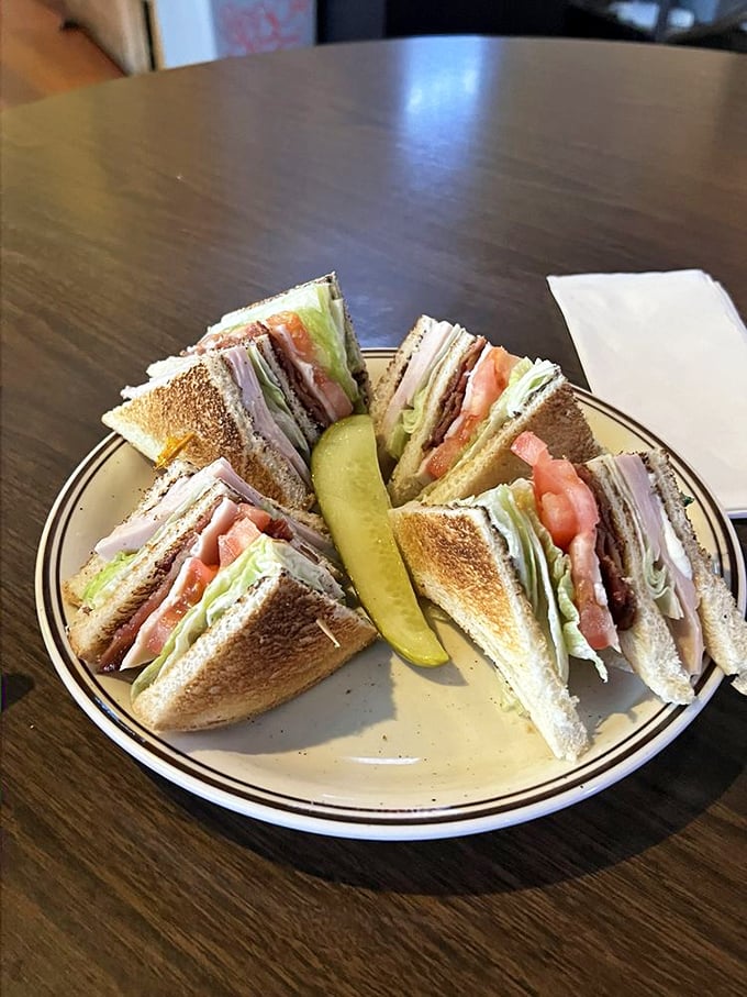 This club sandwich isn't playing around &ndash; perfectly toasted bread, generous fillings, and that pickle standing guard like it means business.