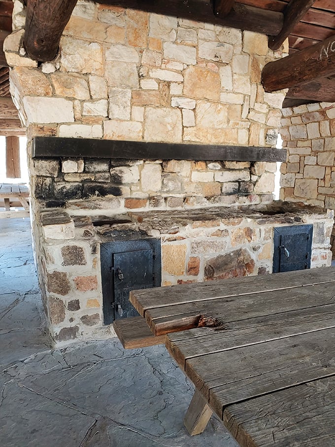 This rustic stone hearth has witnessed countless family gatherings, standing ready for your next outdoor feast.