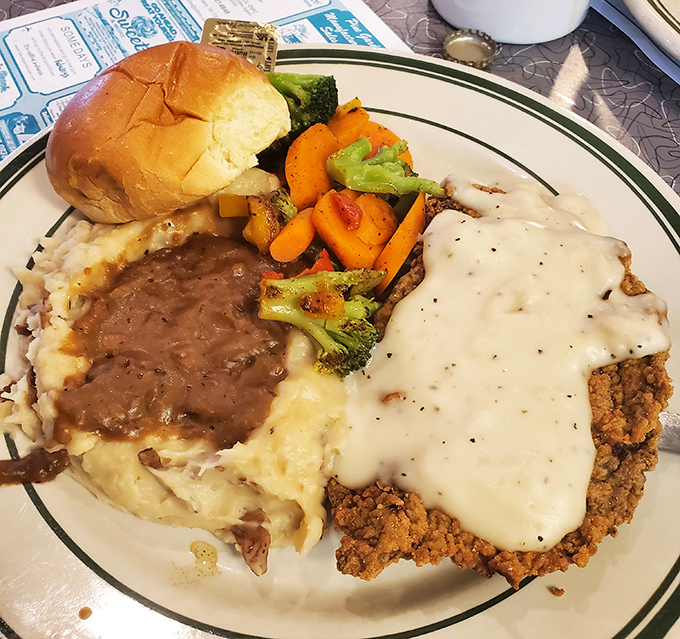 Behold the legendary country fried steak in all its glory&mdash;crispy exterior, tender meat, and that pepper cream gravy that dreams are made of.
