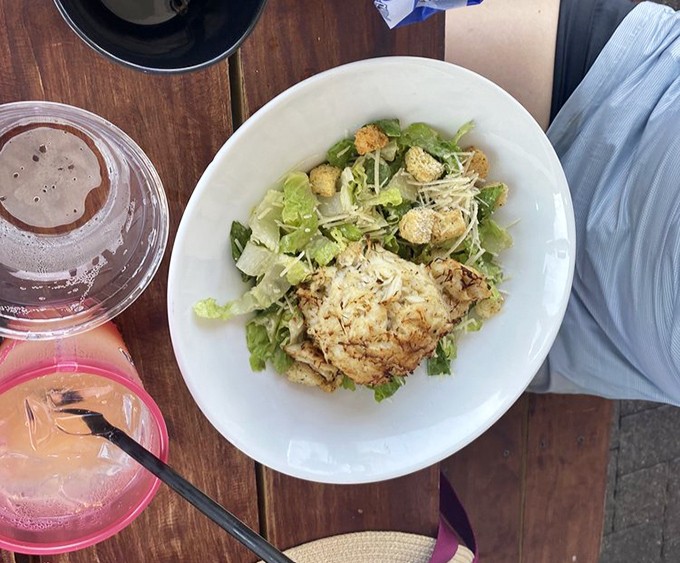 A perfectly golden crab cake nestled atop fresh greens&mdash;Delaware's answer to the age-old question: "What does vacation taste like?"