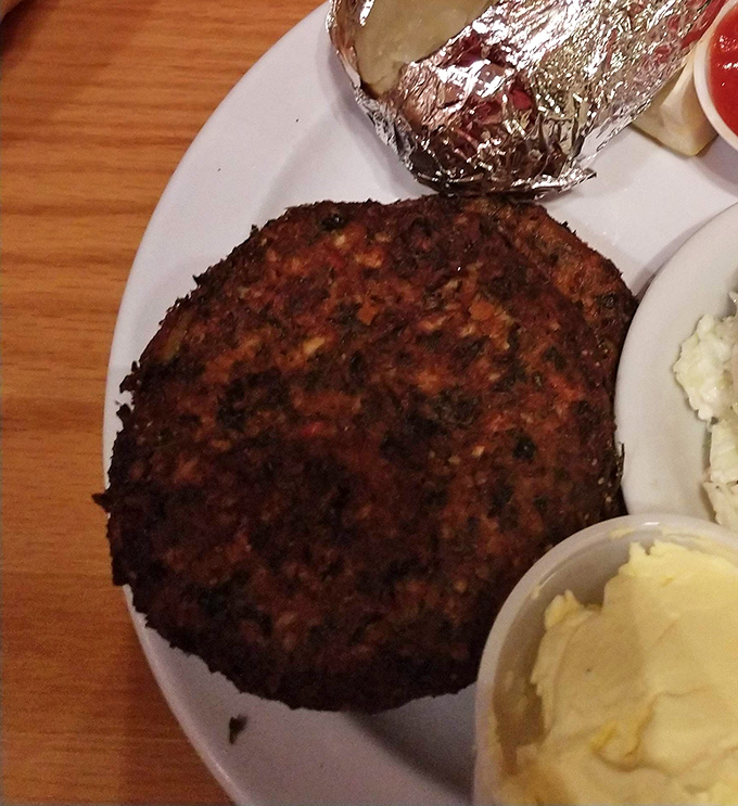 Behold the star attraction: a crab cake that's actually cake-sized, with a perfect golden crust that makes you want to frame it before devouring it.