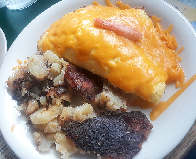 This isn't just breakfast, it's edible architecture &ndash; layers of cheese cascading over protein with potatoes standing guard on the side.