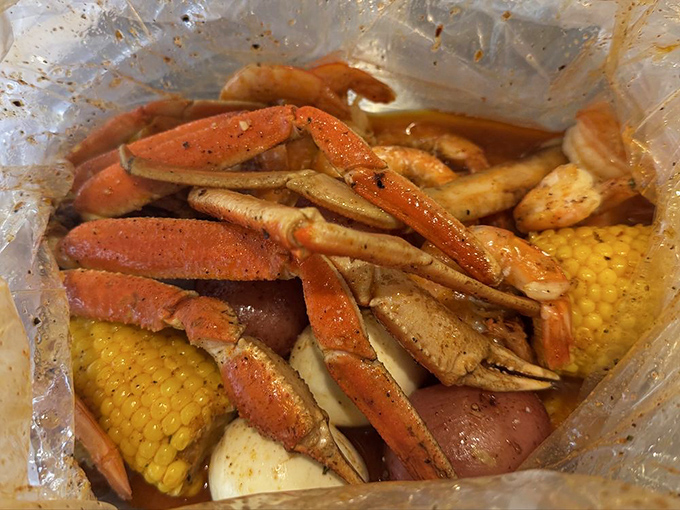 This isn't just dinner; it's an event. Snow crab legs, corn, and potatoes swimming in seasoned butter&mdash;the plastic bag is merely containing the excitement.