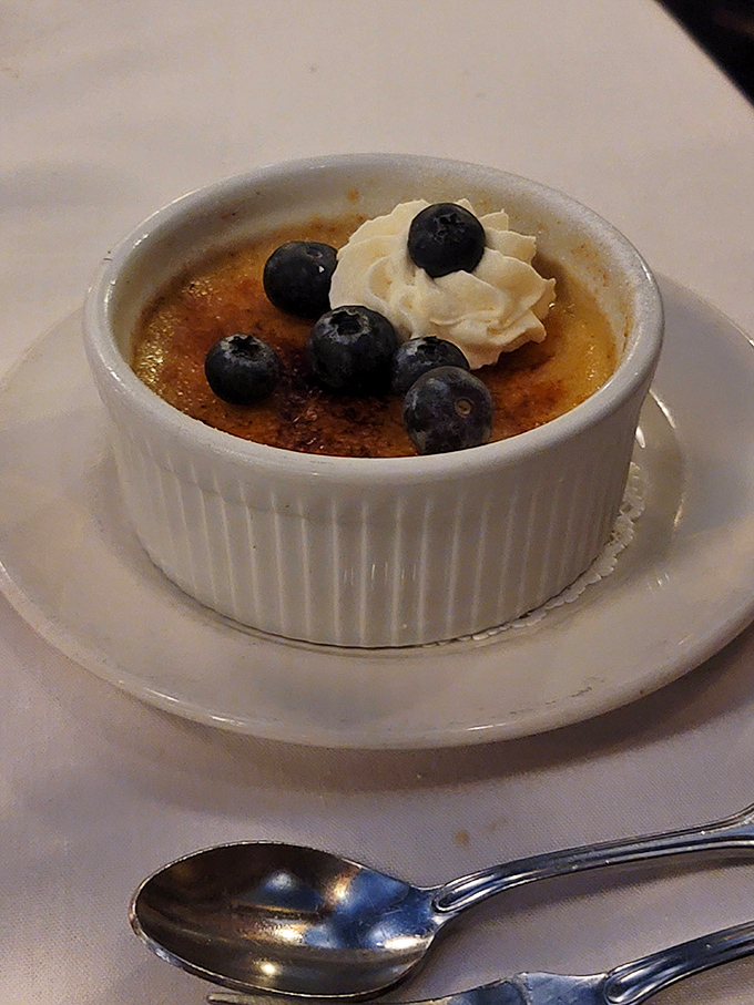 This cr&egrave;me br&ucirc;l&eacute;e doesn't just crack, it shatters expectations &ndash; a silky custard beneath that perfectly torched sugar crust, crowned with fresh blueberries.