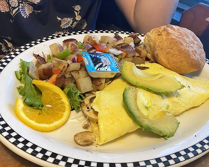 This isn't just an omelet &ndash; it's a golden-hued masterpiece with perfectly saut&eacute;ed veggies, avocado slices, and a biscuit that could make a Southerner weep.