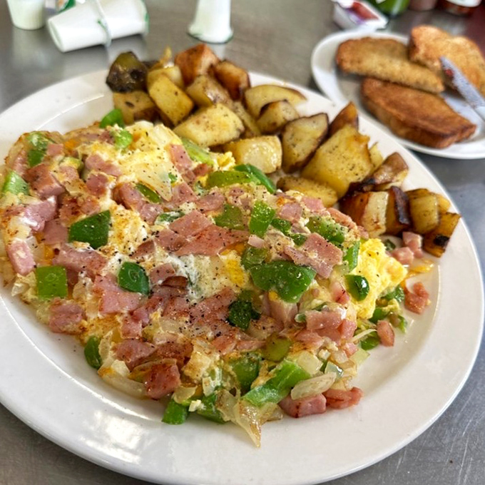 Behold the Denver omelet in its natural habitat&mdash;perfectly fluffy eggs embracing ham, peppers, and onions with those crispy potatoes standing guard. This is breakfast royalty.