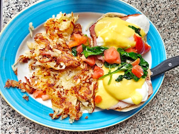 This isn't just eggs Benedict&mdash;it's a masterclass in morning perfection with spinach and tomato adding color to that sunshine-yellow hollandaise.