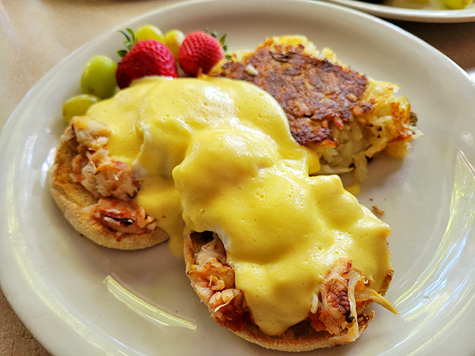 Eggs Benedict reimagined with what appears to be crab beneath that sunshine-yellow hollandaise. The crispy hashbrowns are non-negotiable companions.