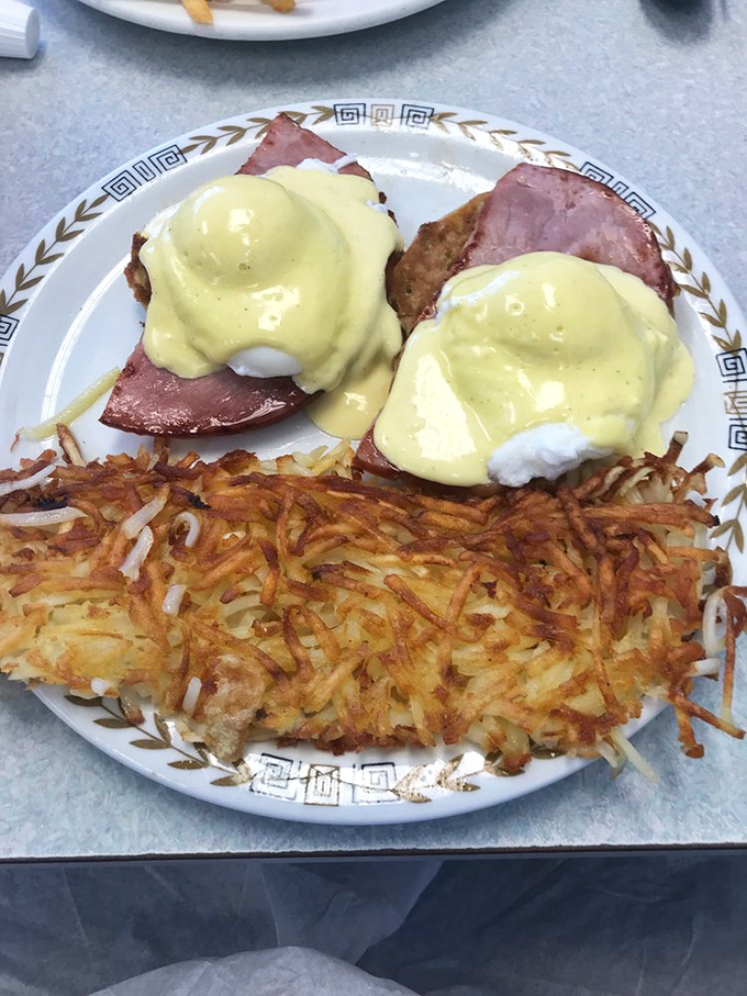 Behold the star attraction: perfectly poached eggs draped in hollandaise that cascades like a buttery waterfall over Canadian bacon and a toasted English muffin.