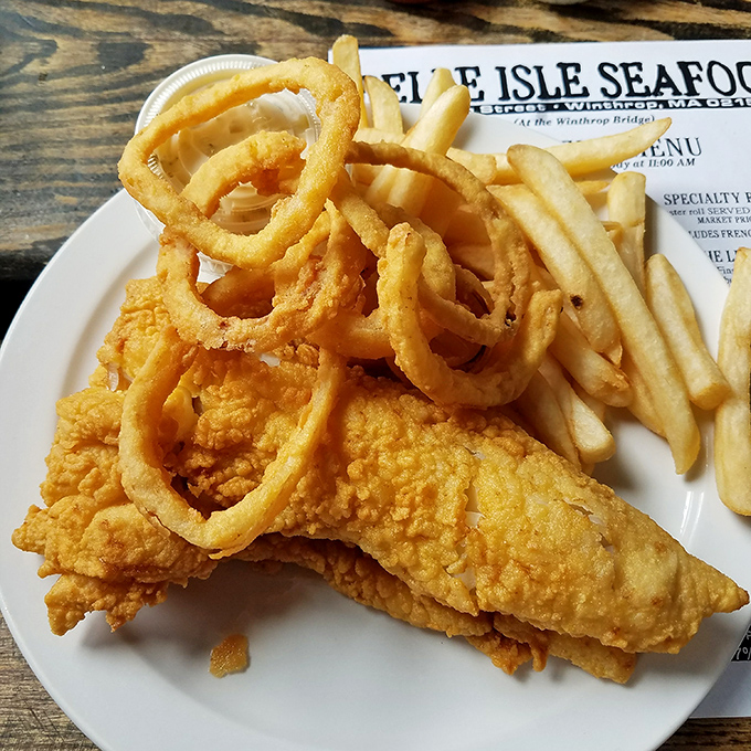 Golden-battered fish and crispy onion rings share the spotlight on a plate that proves simplicity is the ultimate sophistication when ingredients are this fresh.