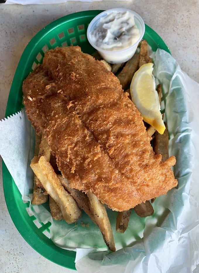 Golden-battered fish rests atop a bed of crispy fries, a simple pleasure elevated to art form. That tartar sauce deserves its own fan club.