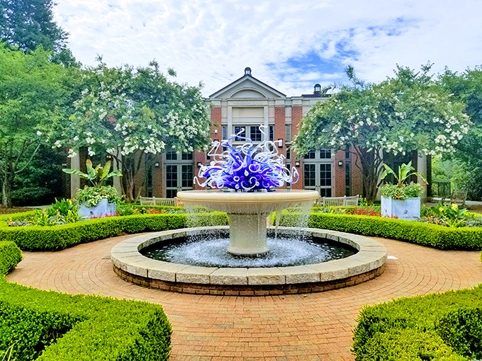 A blue glass masterpiece dances atop this fountain, like frozen water deciding it preferred life as art.