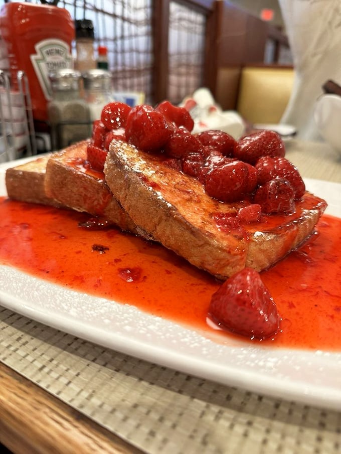 French toast that's having an identity crisis as a berry swimming pool. Those strawberries aren't garnish&mdash;they're throwing a party.