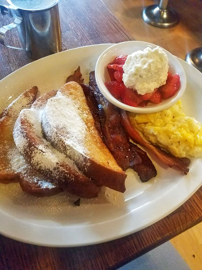 French toast that's dressed for success with powdered sugar, fresh berries, and that perfectly crisp bacon&mdash;breakfast's holy trinity on a single plate.