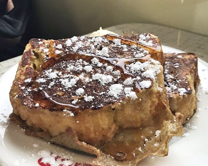 French toast that looks like it graduated from culinary school with honors. That powdered sugar snowfall and glistening maple syrup? Pure breakfast poetry on a plate.