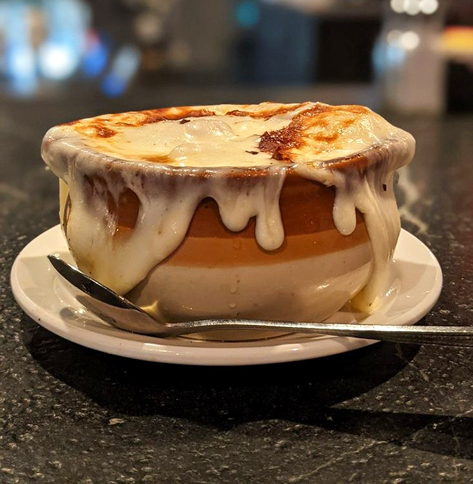 Behold the French onion soup in all its molten glory! That cheese pull could win Olympic medals, while the rich broth below has been known to inspire spontaneous poetry.