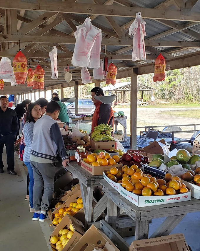 Farm-fresh bounty displayed on weathered tables, where shoppers haggle over plump oranges and perfectly ripe bananas.