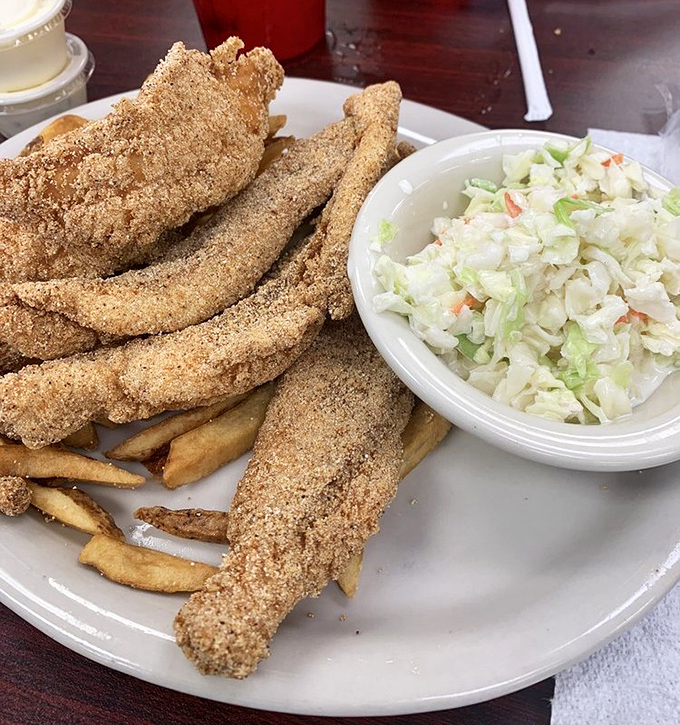 Golden-crusted catfish fillets that snap with each bite, paired with creamy coleslaw that balances the richness perfectly.