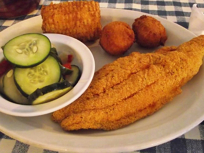 Golden-crusted catfish that breaks apart with the gentlest fork pressure, paired with crispy hush puppies and fresh cucumber salad &ndash; the holy trinity of Southern comfort.