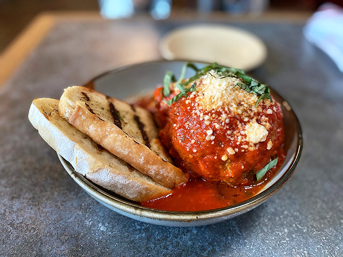 Behold the spherical legend itself, swimming in marinara with grilled bread standing by like loyal soldiers ready for duty.