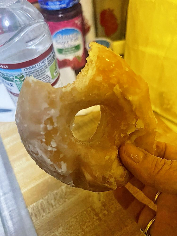 Behold the anatomy of perfection: a half-eaten glazed donut revealing its airy, honeycombed interior. This is what breakfast enlightenment looks like, my friends.