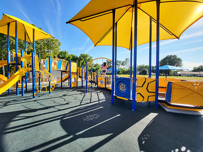Bright yellow canopies and blue equipment create a playground paradise where kids can burn energy while parents enjoy a moment's peace.