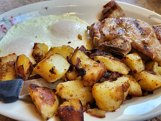 Golden home fries that crackle with each bite, sitting alongside eggs that would make any chicken proudly take a bow.
