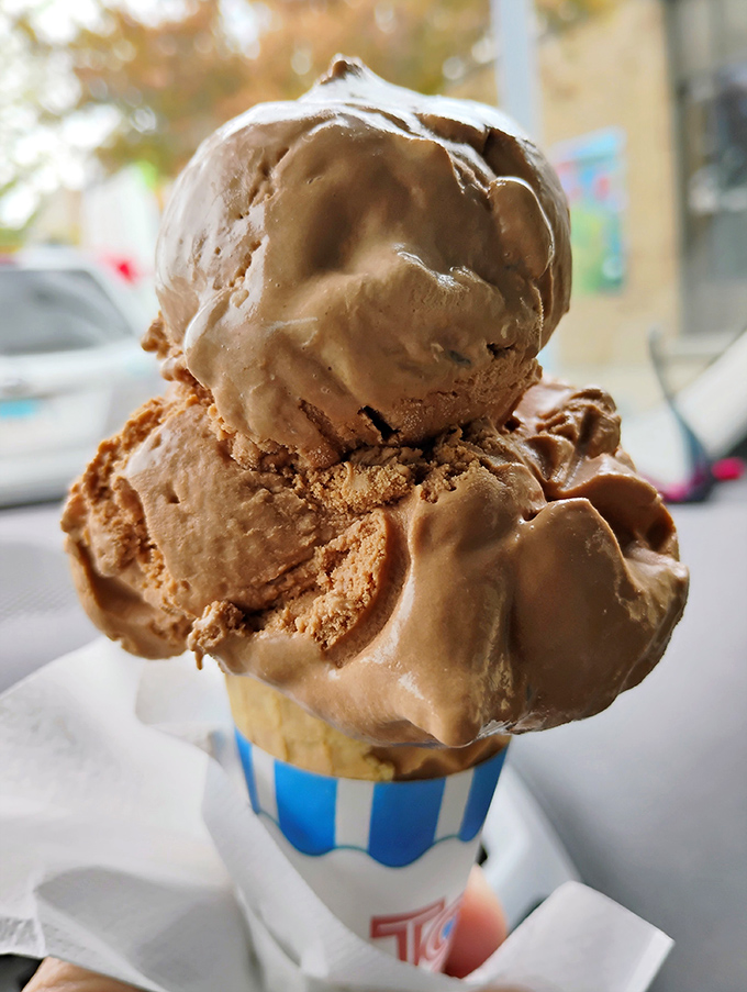 Behold: three perfect scoops defying gravity and good sense, proving that architectural excellence extends beyond buildings into cones.