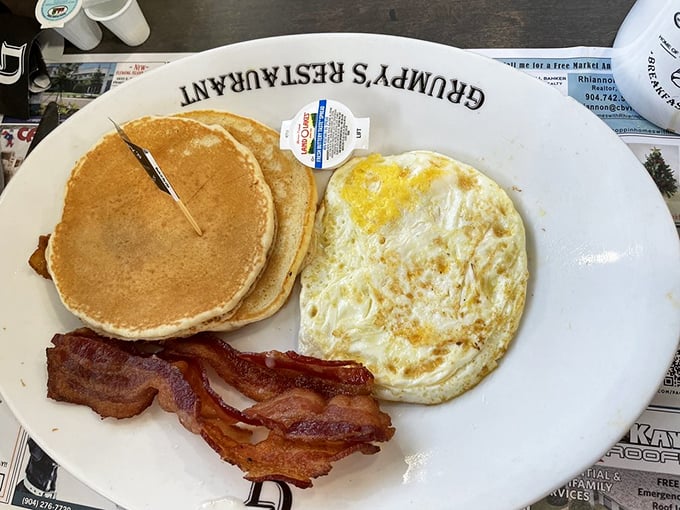 The breakfast trinity: golden pancakes, perfectly sunny eggs, and bacon that's achieved that mythical balance between crispy and chewy. Hallelujah!