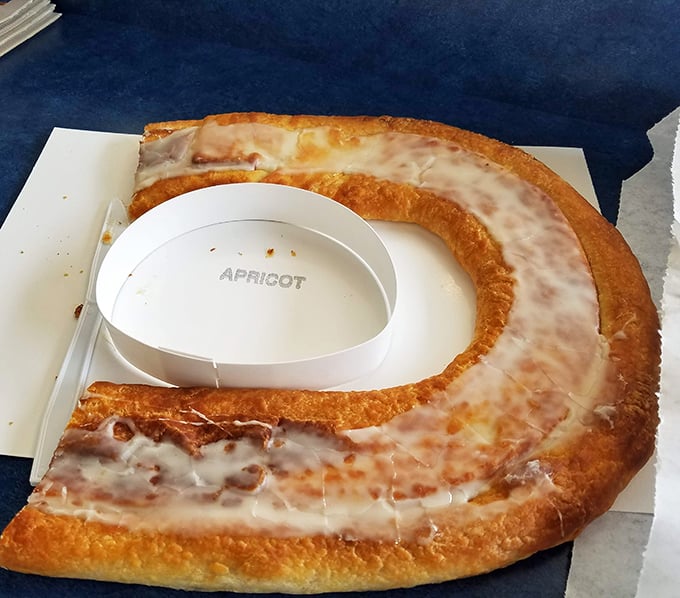 Behold the crown jewel of Danish-American baking: the apricot kringle in all its oval-shaped glory, where flaky pastry meets sweet filling in perfect harmony.