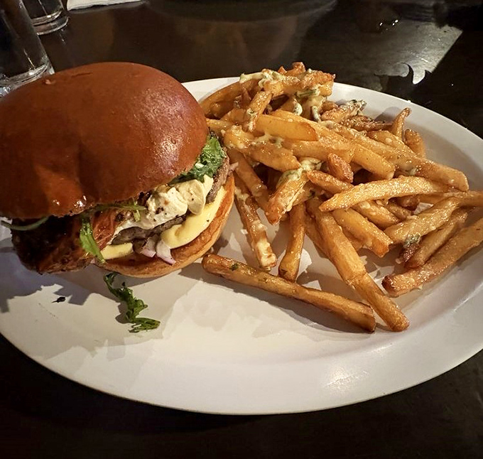 Behold the star of the show: a perfectly crafted burger alongside golden fries. This plate doesn't need Instagram filters&mdash;it's already food perfection.