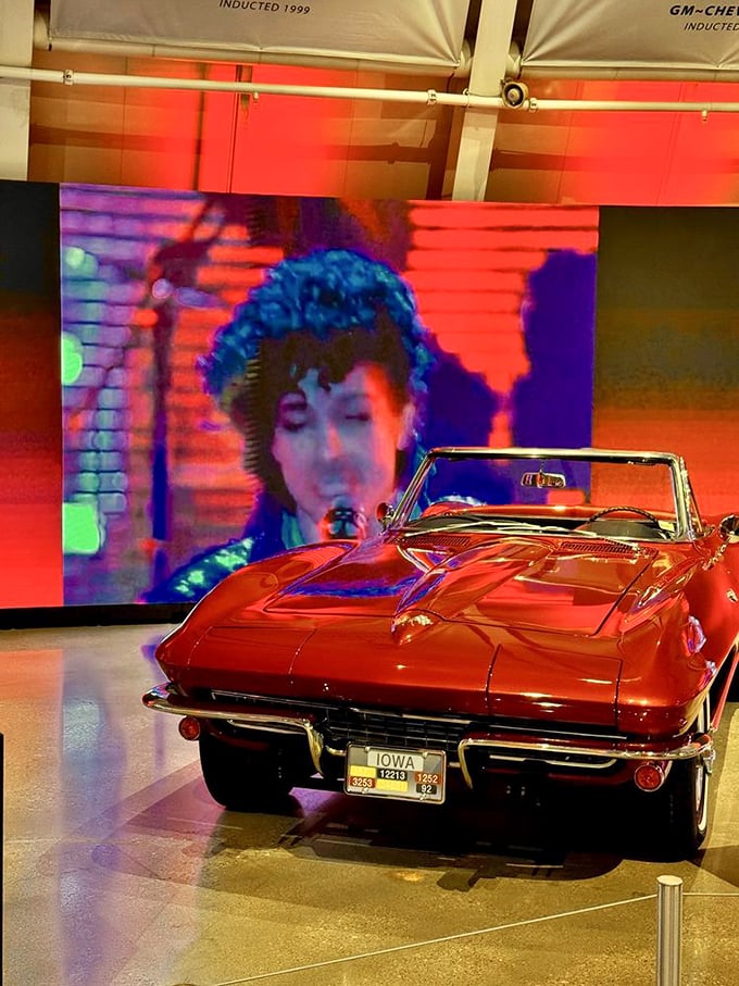 This fiery red convertible sits beneath pop culture imagery, reminding us that Corvettes aren't just cars&mdash;they're starring characters in America's ongoing love affair with the open road.