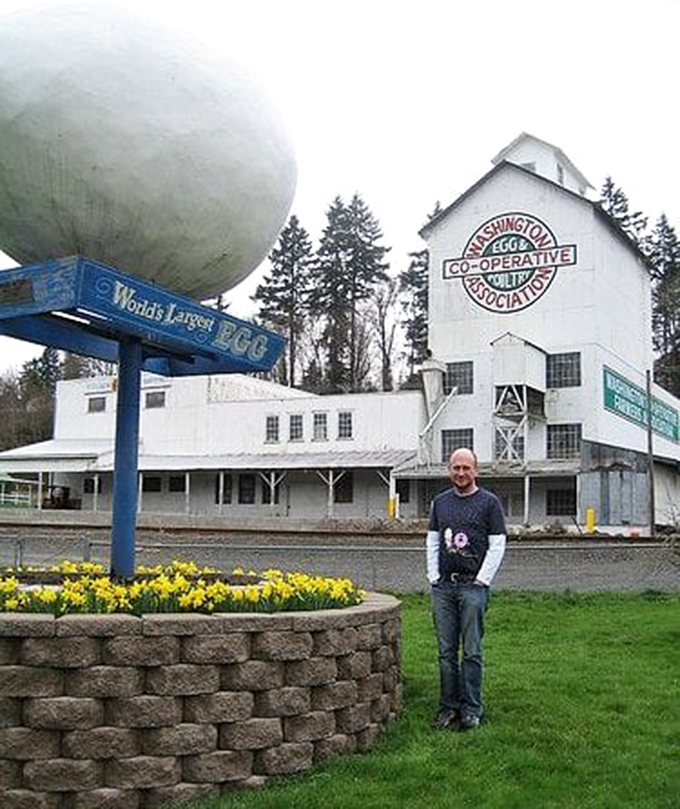 Size matters! A visitor provides perfect scale for this enormous egg, proving that sometimes the most memorable attractions come in the most unexpected packages.