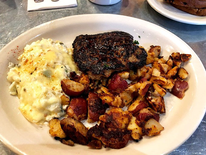 A mountain of seasoned potatoes alongside perfectly cooked eggs and a hearty sausage patty. Breakfast architecture at its finest.