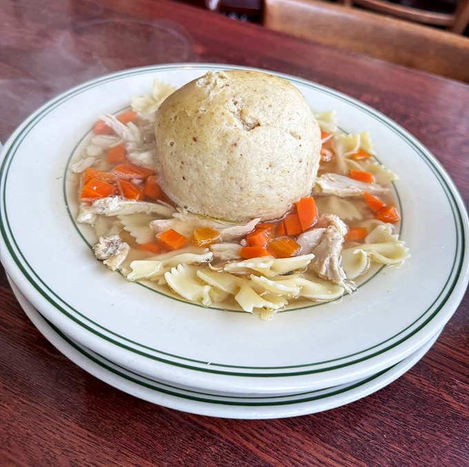 The matzo ball soup's golden broth cradles a cloud-like dumpling that's achieved the perfect balance between "grandma's recipe" and "how is this so light?"