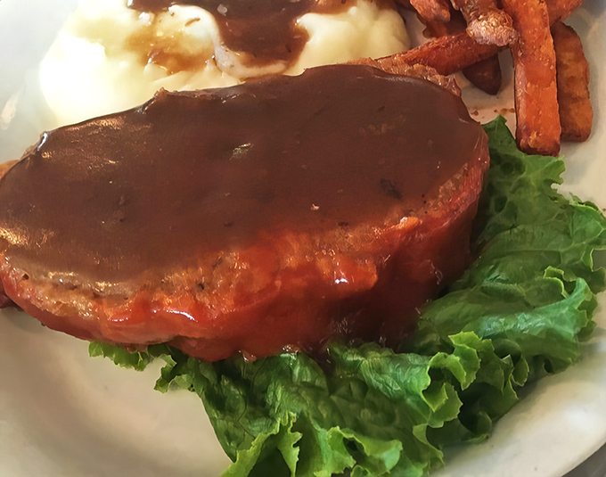 This isn't just meatloaf &ndash; it's a masterclass in comfort food architecture, with perfectly seasoned meat, savory gravy, and a bed of fresh lettuce.