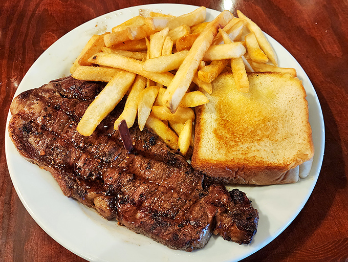 Behold the star of our show: a perfectly seared New York Strip with those coveted grill marks that whisper, "Yes, this was worth the drive."
