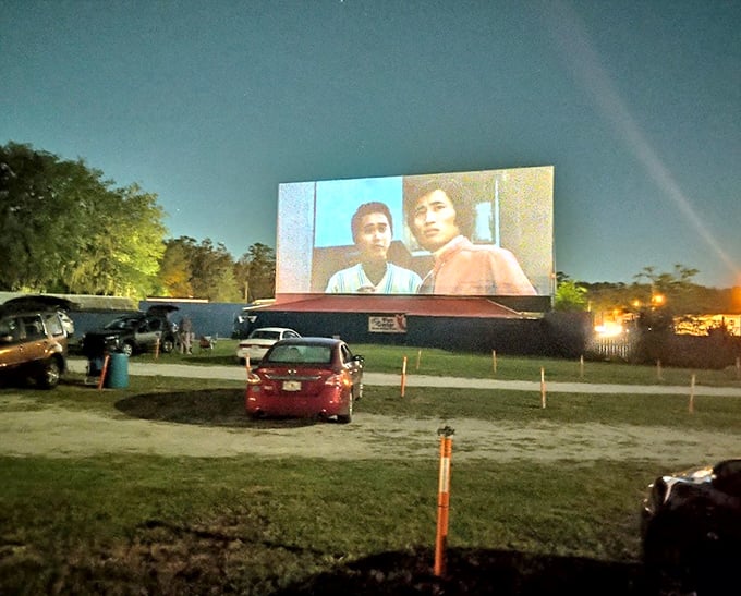 As darkness falls, the massive screen illuminates with cinematic glory, turning ordinary cars into personal theaters under the stars.