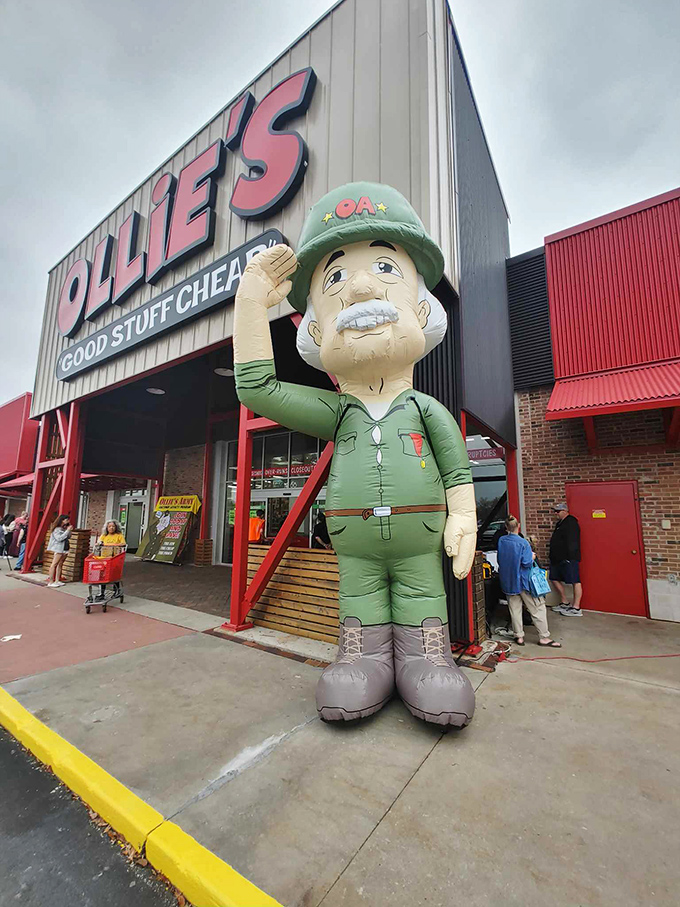 The jolly Ollie's mascot stands guard outside, saluting bargain hunters like a general welcoming troops to the frontlines of frugality.