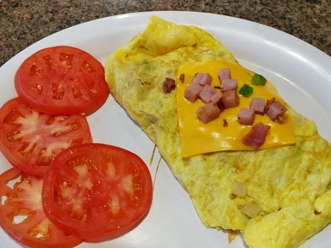 Behold the ham and cheese omelet in its natural habitat&mdash;perfectly folded, generously stuffed, and flanked by sliced tomatoes like loyal bodyguards.