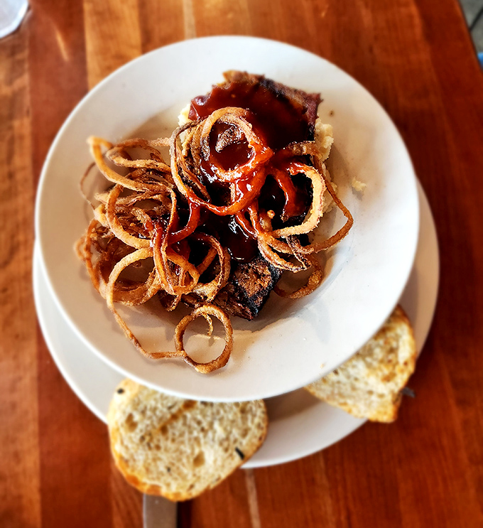 These golden spirals aren't just onion rings – they're crispy halos that have achieved legendary status worldwide.